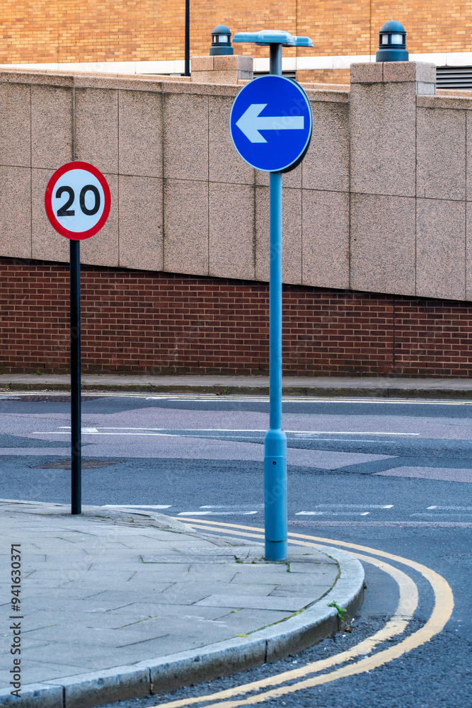 This image features a close-up of traffic signs in an urban setting ...