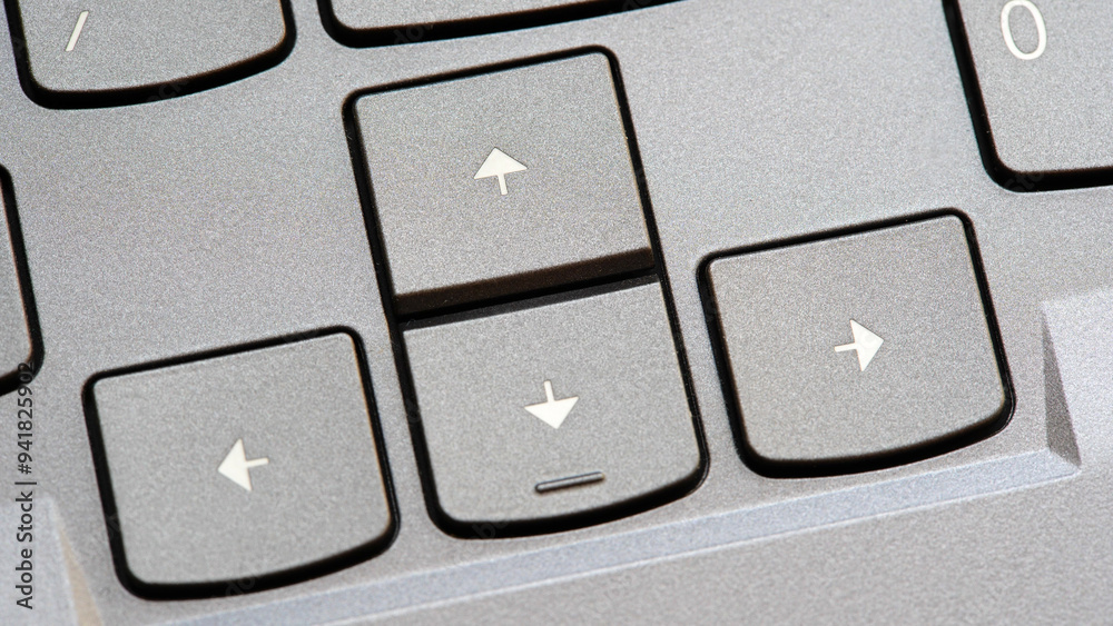Gray arrow keys on a new modern laptop keyboard, high angle, top view ...