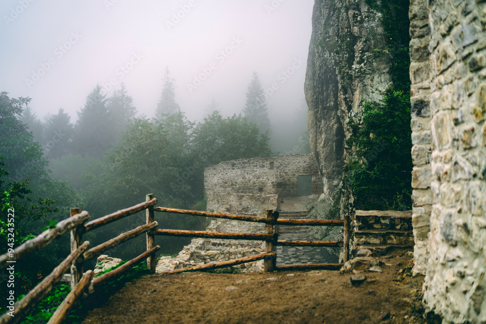 Sumela Monastery. Wooden railing area on the road to the monastery. Sumela covered with foggy ...