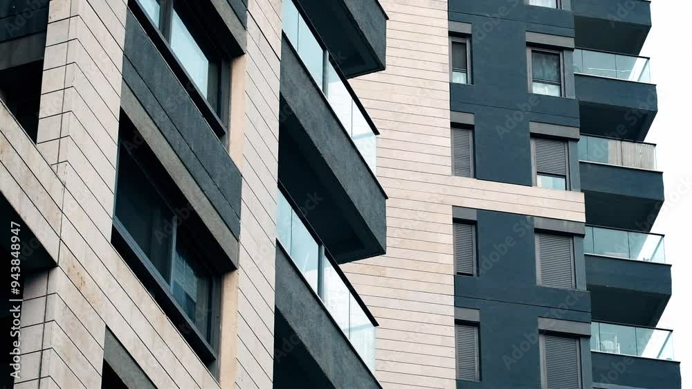 A part of a 15 stories residential building, with balconies and windows ...