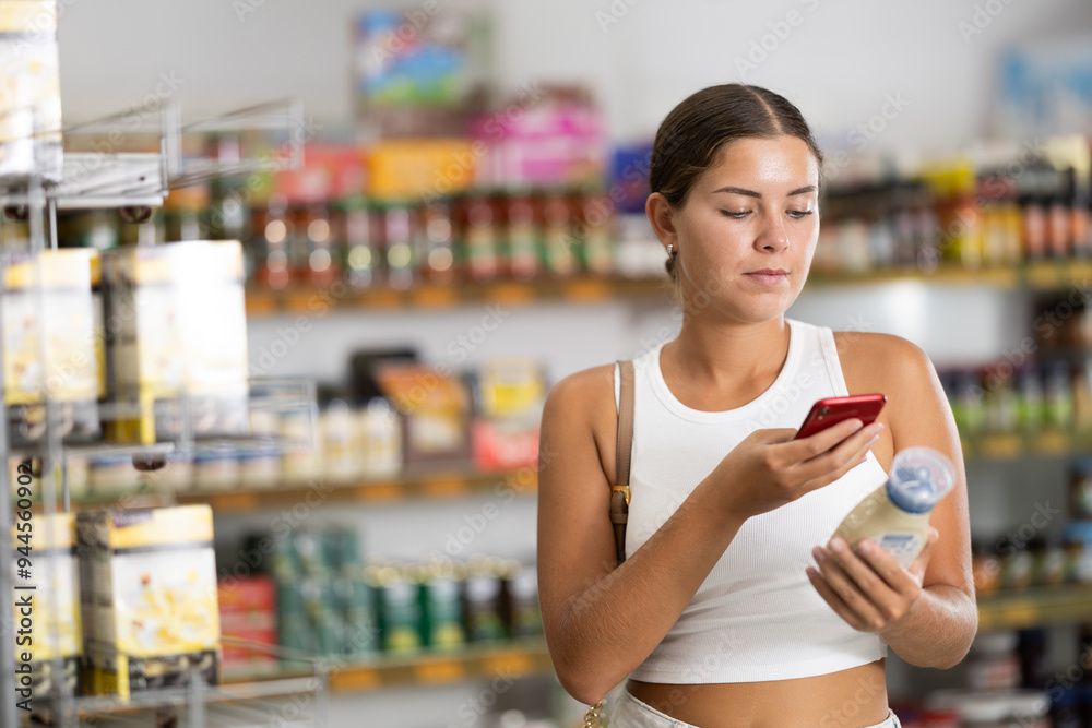 Young female shopper scanning qr code for mayonnaise sauce in ...