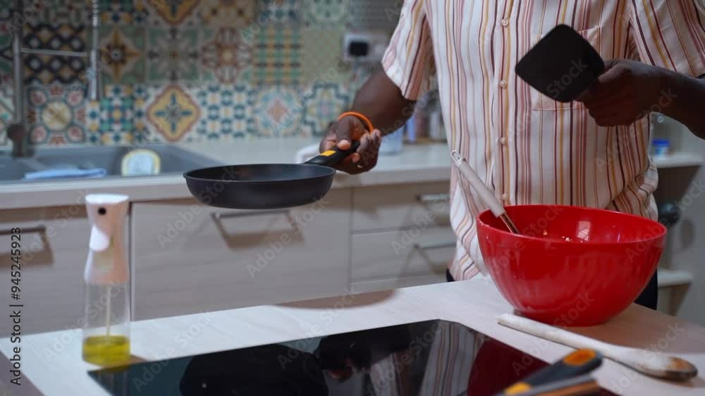 African American father man hand frying pancakes together with daughter ...