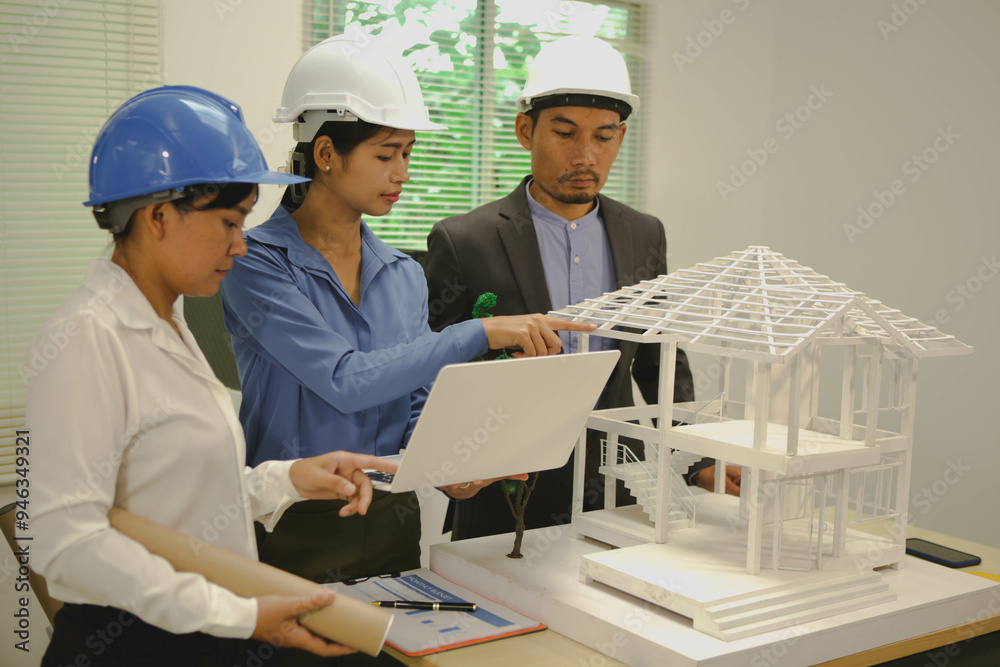 Engineers are discussing house construction plans, reviewing blueprints ...