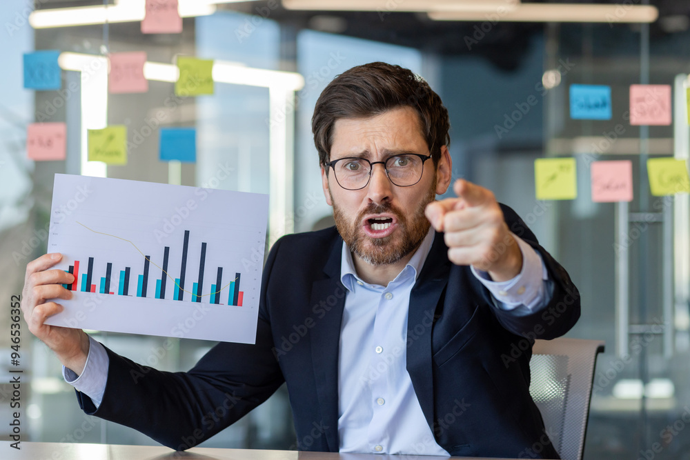 Angry businessman engages in video call, holds chart indicating ...
