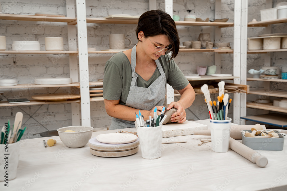 Wedging the clay before starting making a pottery project to create ...