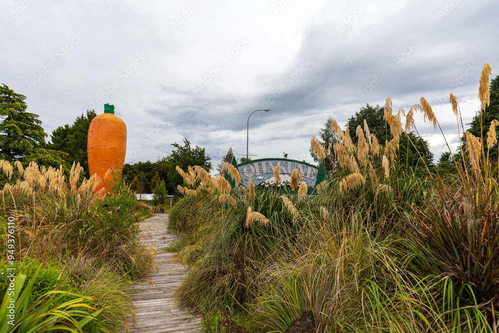 A serene wooden pathway winds through lush greenery, leading to the ...