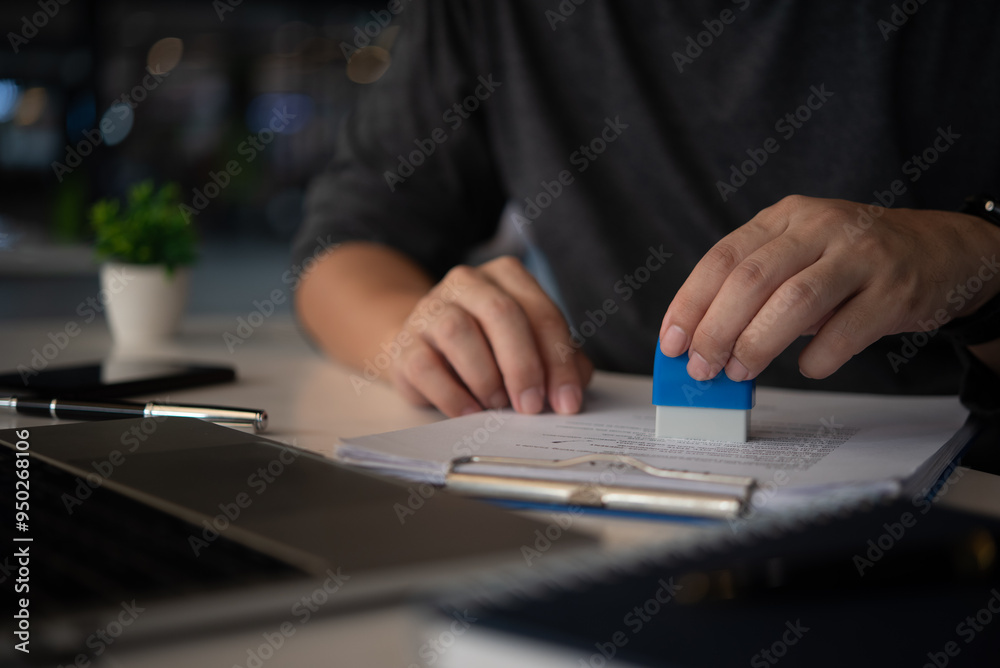 person stamping documents in an office setting, representing document ...