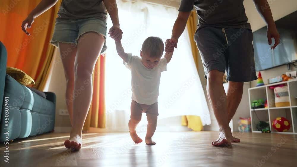 Mother and father help son take. Baby first step with parents support ...