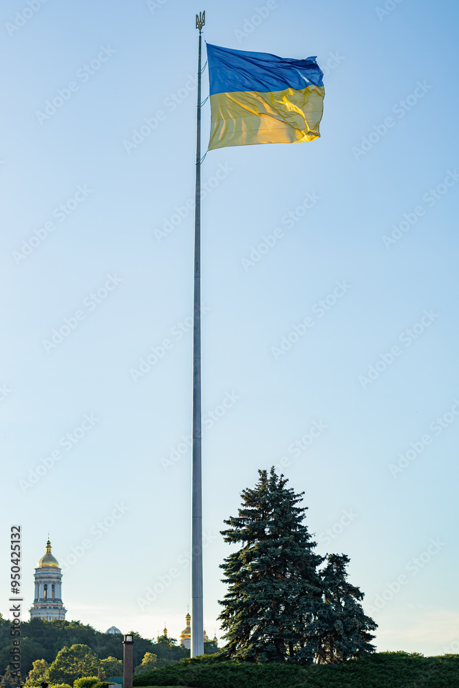 Ukrainian flag flying high on a flagpole against a clear blue sky, with ...