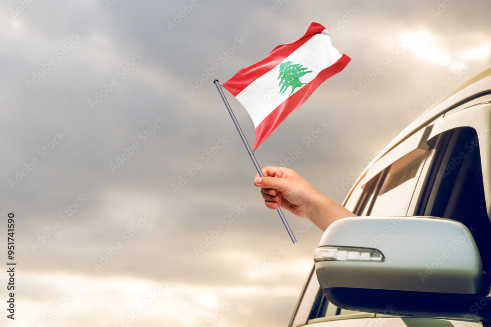 Waving the Lebanon flag against the sunrise or sunset from a car ...