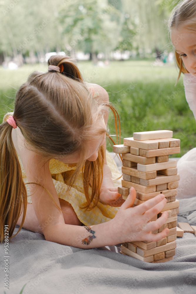 Preschool girls carefully stacking wooden blocks while playing tower ...
