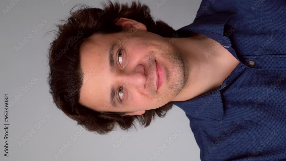 Portrait of man looking by sides with sly tricky face on gray ...