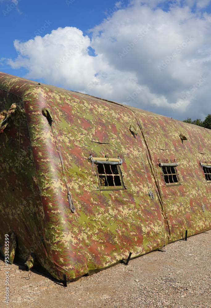 camouflaged military tent set up in a training camp during wartime with ...