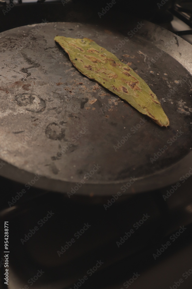 vertical photo of a nopal roasted on a hot griddle, on the stove. Stock ...