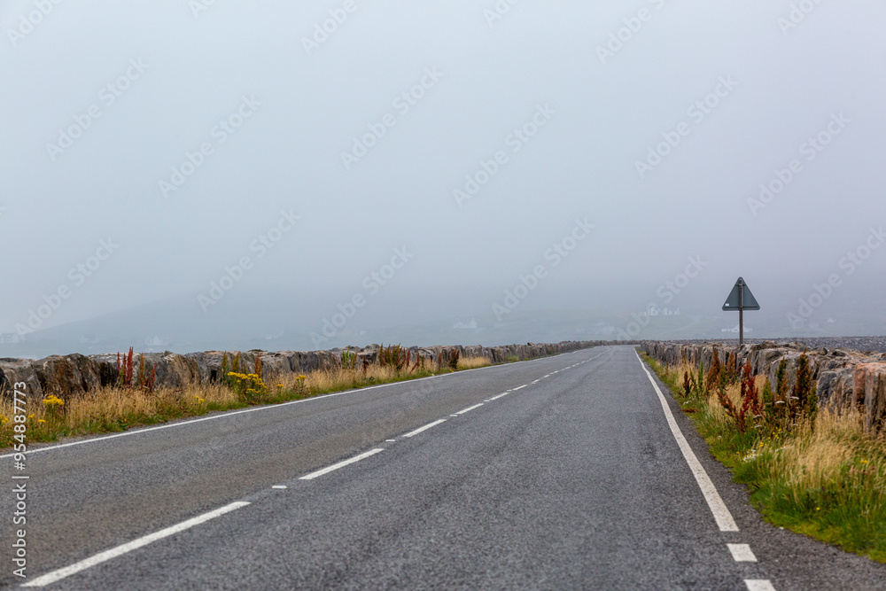 Eriskay causeway on a foggy day, Image shows the causeway connecting ...