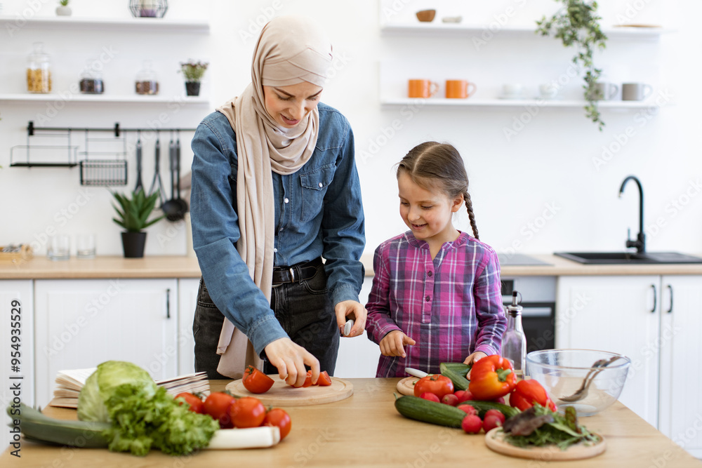 Happy child learning food preparation with parent. Muslim mother and ...