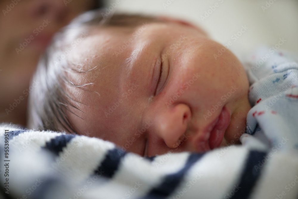 Newborn baby sleeping soundly on mother’s chest, showing the ...