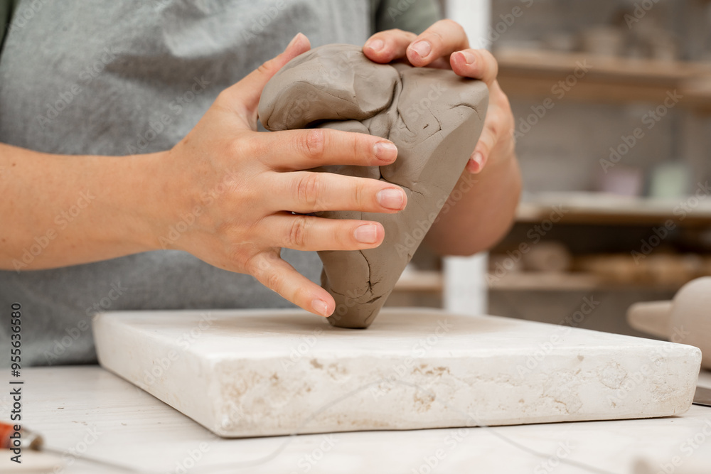 Wedging the clay before starting making a pottery project to create ...
