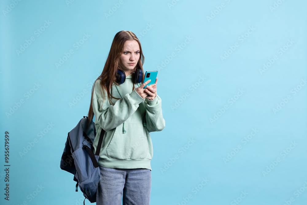 Teenager frowning while reading messages on phone, feeling shocked ...