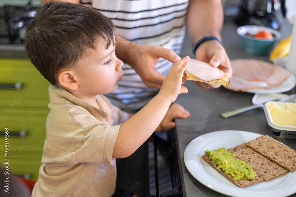 dad and son in modern kitchen eating breakfast.father doing tasty ...