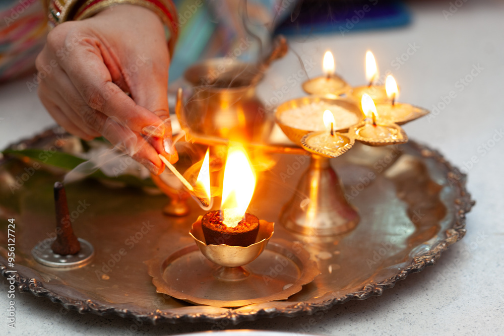 Puja or Arti thali with a brass oil lamp. An Indian woman lights a ...