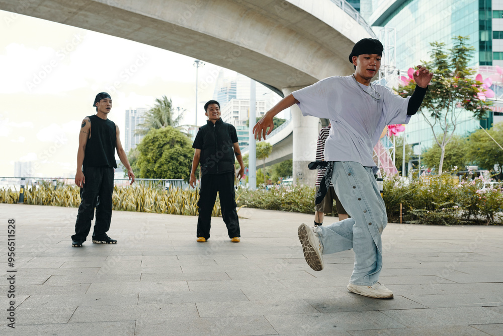 Group of young men performing street dance moves in urban environment ...