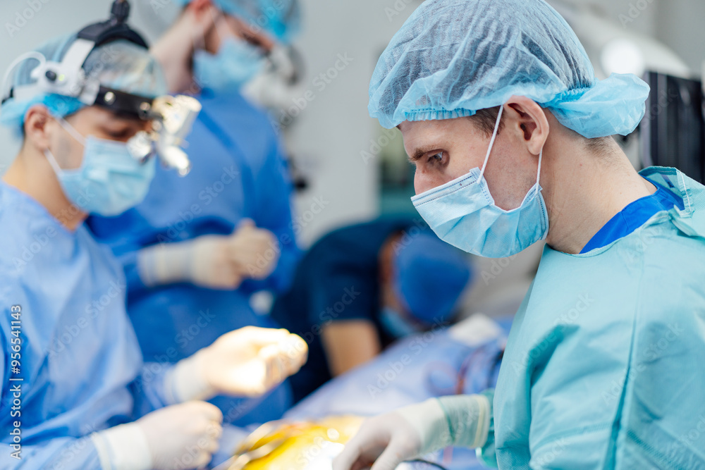 Surgical team performing an operation in a modern hospital setting. A ...