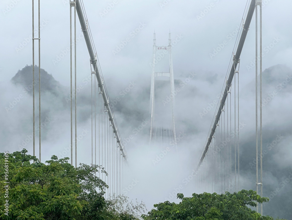 Aizhai Bridge in clouds, suspension bridge across the valley with ...