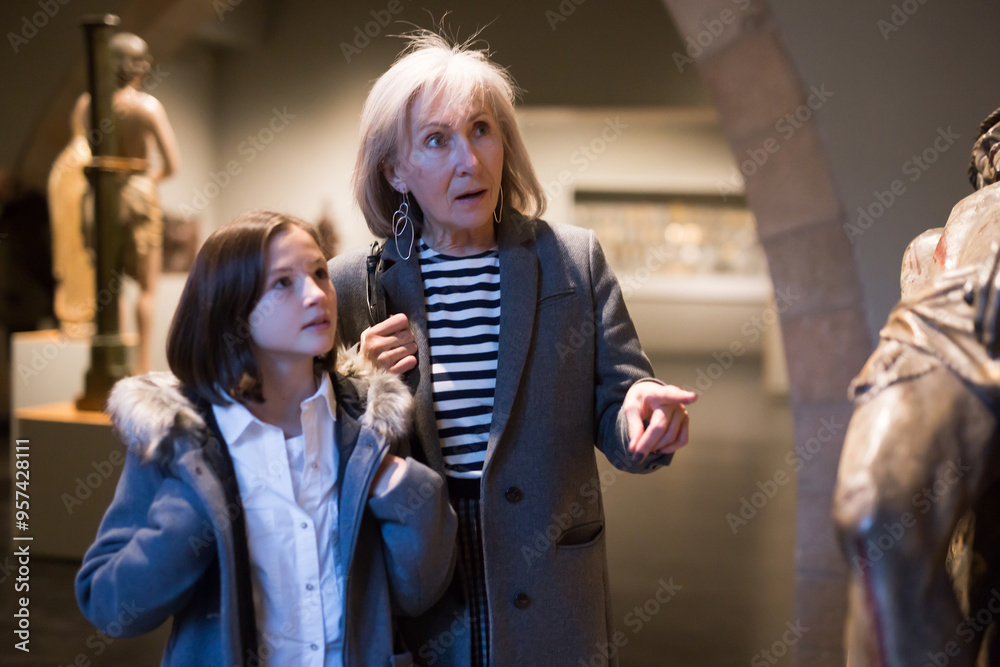 Inquisitive preteen girl visiting museum of ancient sculpture with her ...