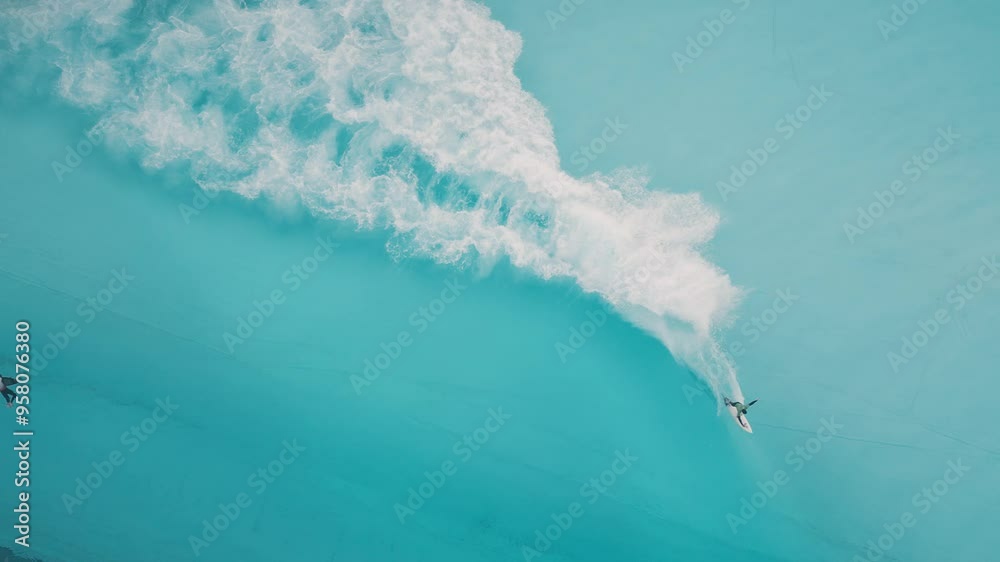 Surfing in the pool. Top down aerial view of the surfers riding wave in ...