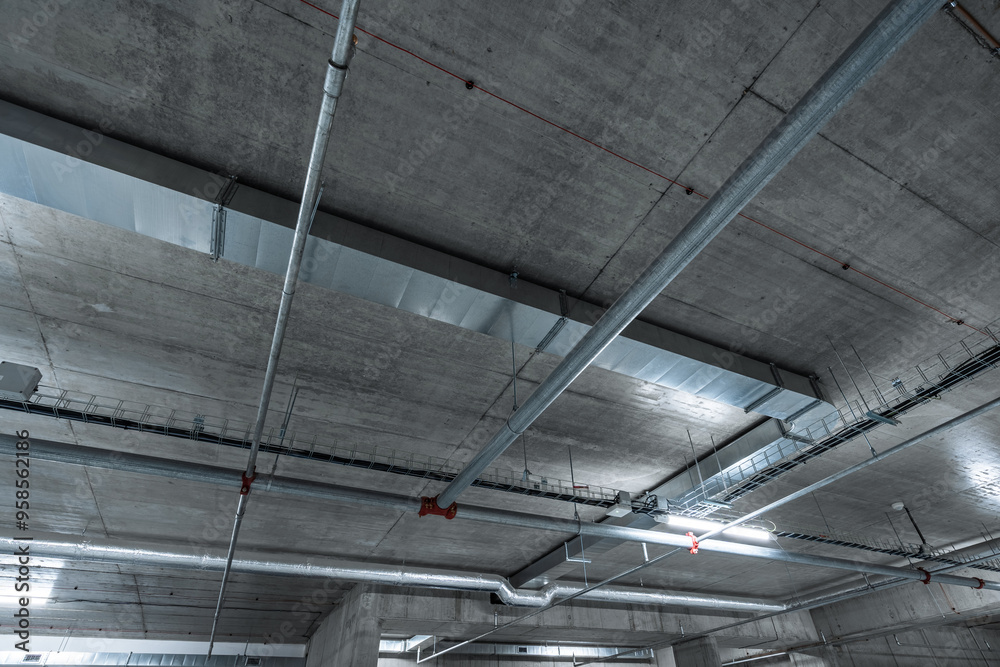 Ceiling view of an industrial structure featuring pipes, ducts, and ...