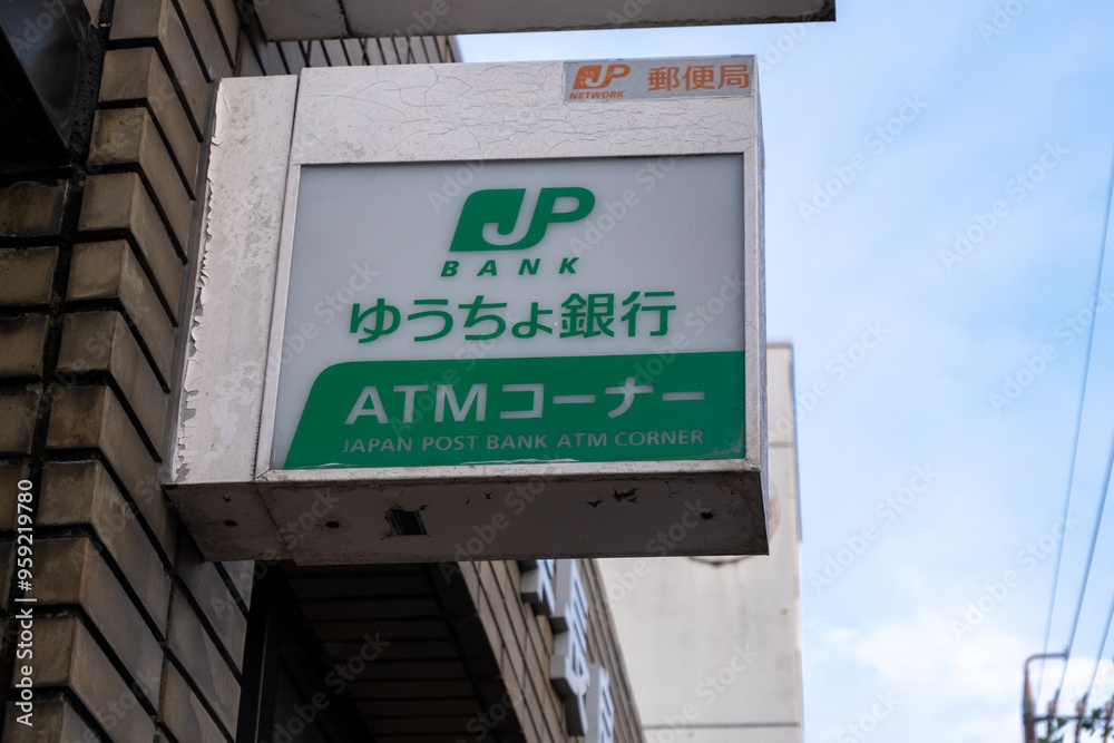 A logo and sign of Japan Post Bank indicates that an ATM is available ...
