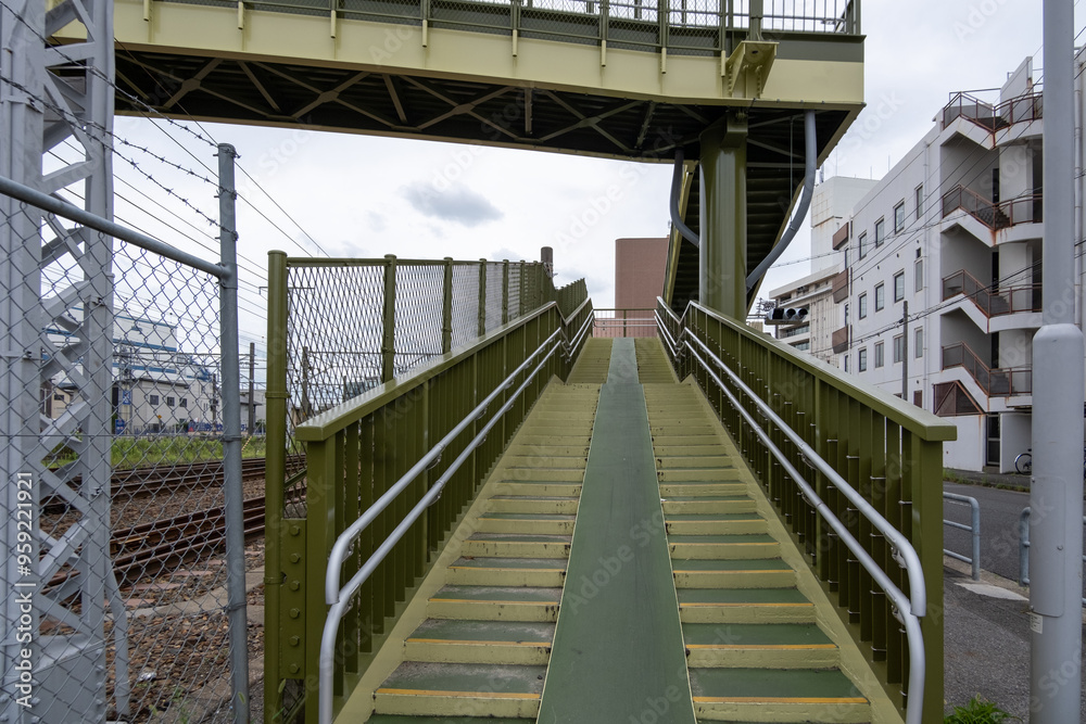 A pedestrian bridge with a bike ramp for wheeling bicycles up leads ...