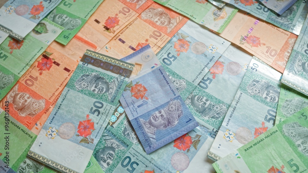 Malaysian banknotes of various denominations are scattered across a ...
