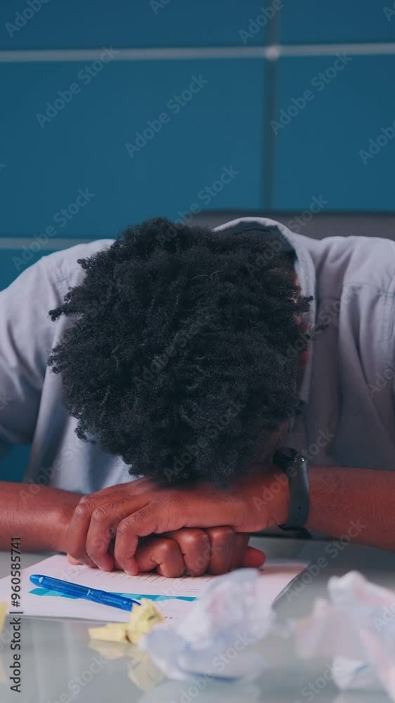 A young student expresses frustration while resting their head on a ...