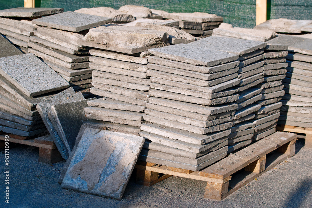 Road reconstruction, old paving slabs and stones stacked on pallet ...