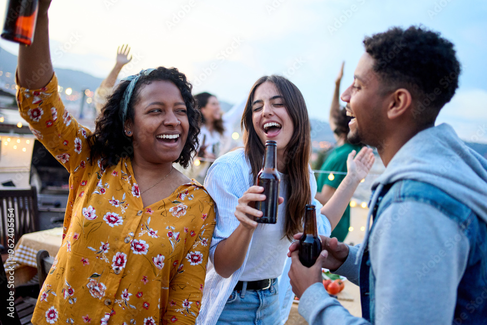 Three diverse young excited friends dancing together using beer bottles ...