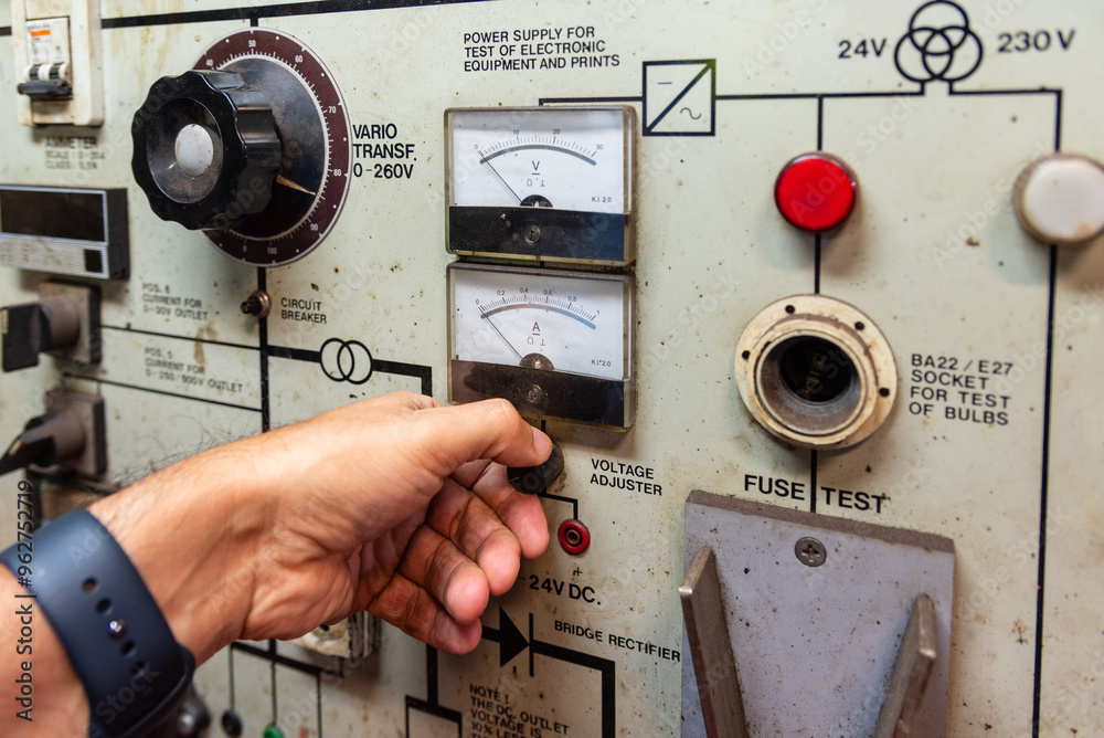 A worker’s hand, steady and focused, adjusts settings on a control ...