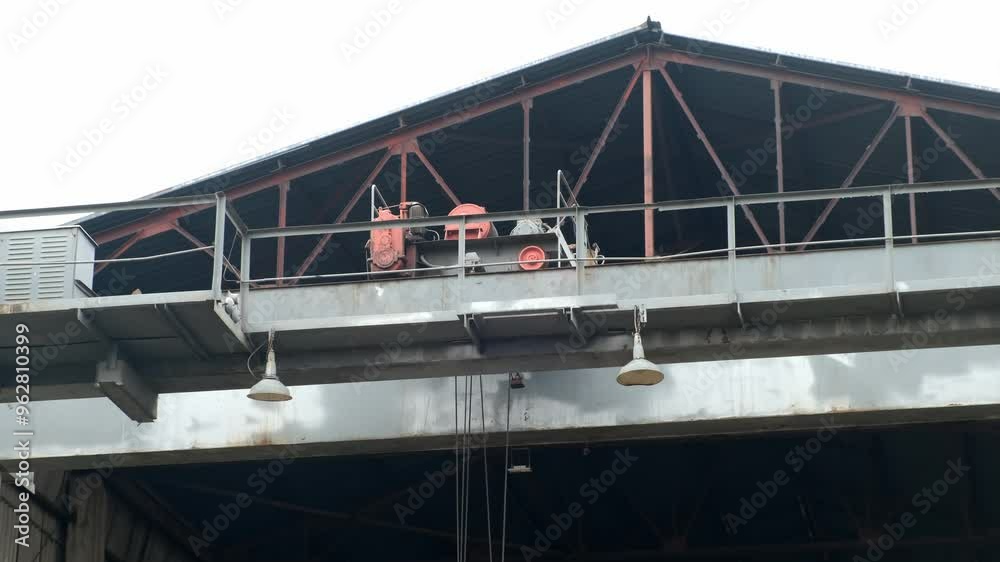 Overhead lifting crane moving along tracks on construction factory ...