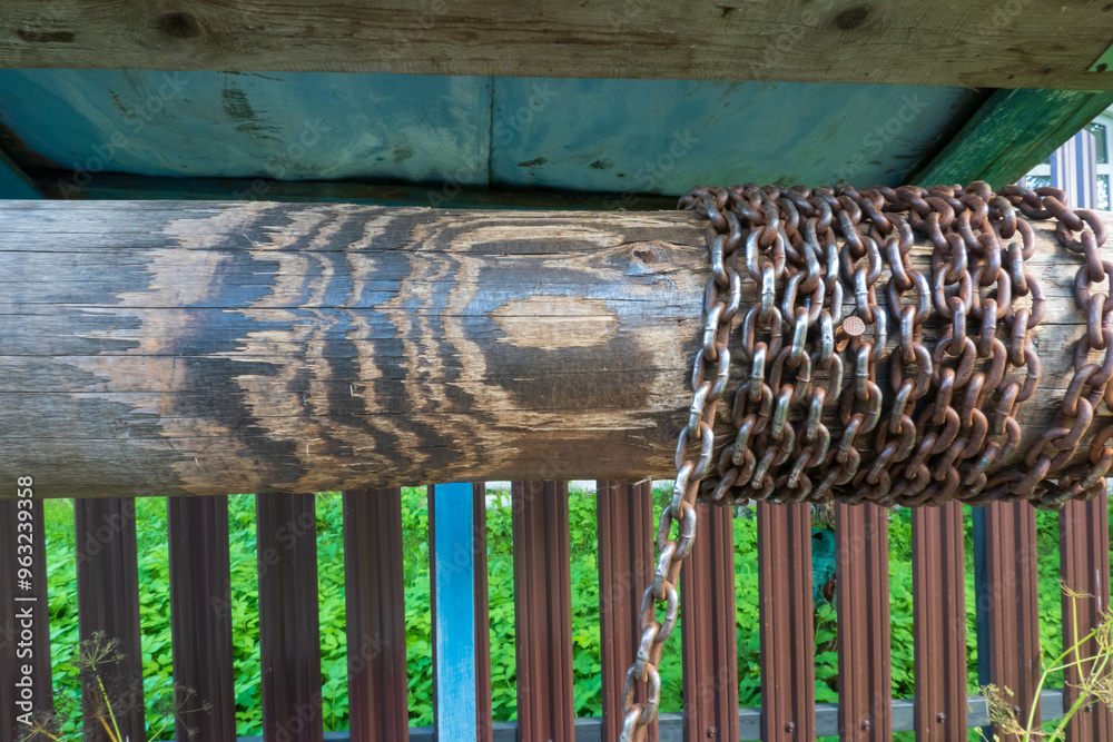 Old wooden shaft for winding chain at a well made of pine log. There ...
