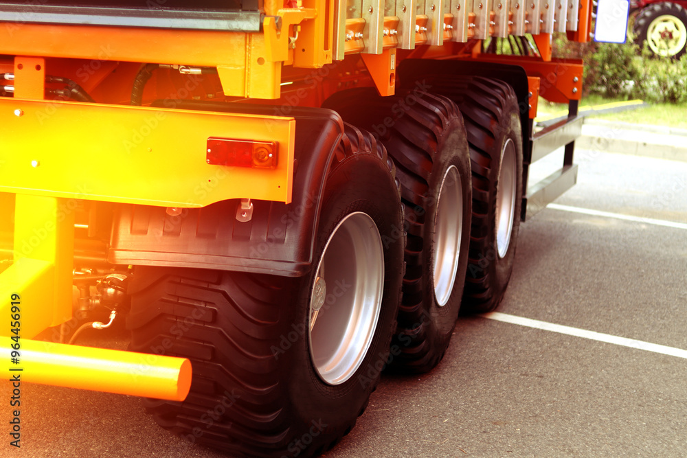 Dump truck wheels with all-season tires on an asphalt road. Close-up of ...