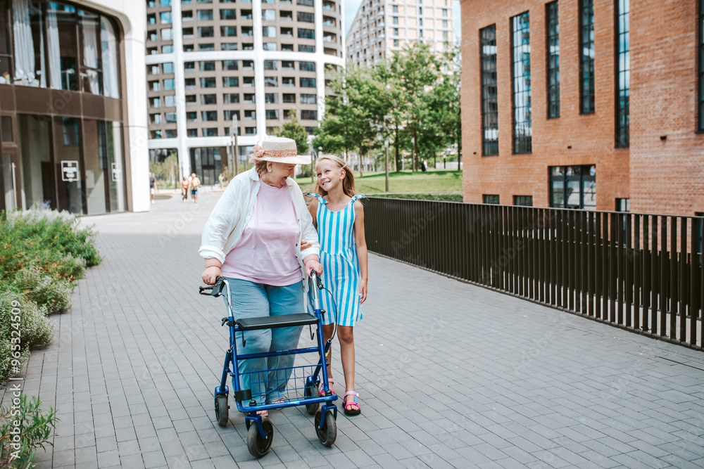 Grandma with walker and granddaugter in the city, on walk. Girl ...