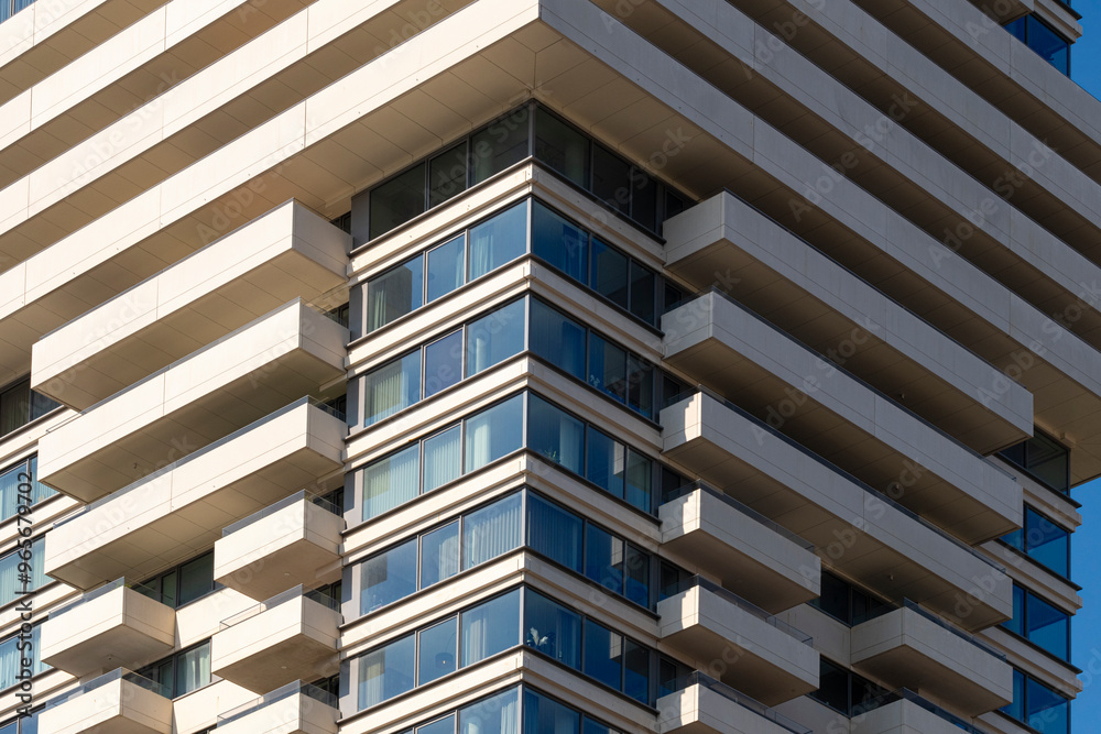 The photograph shows an upward angle of a tall, modern building ...