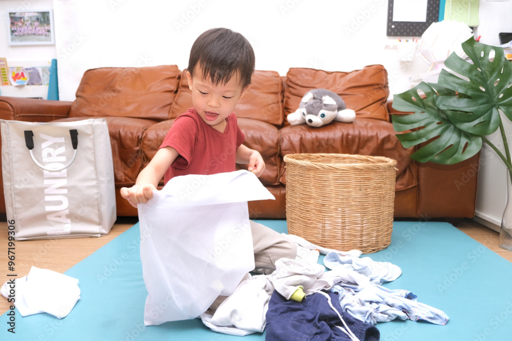 Cute happy healthy smiling Asian 4 years old boy child doing laundry at ...