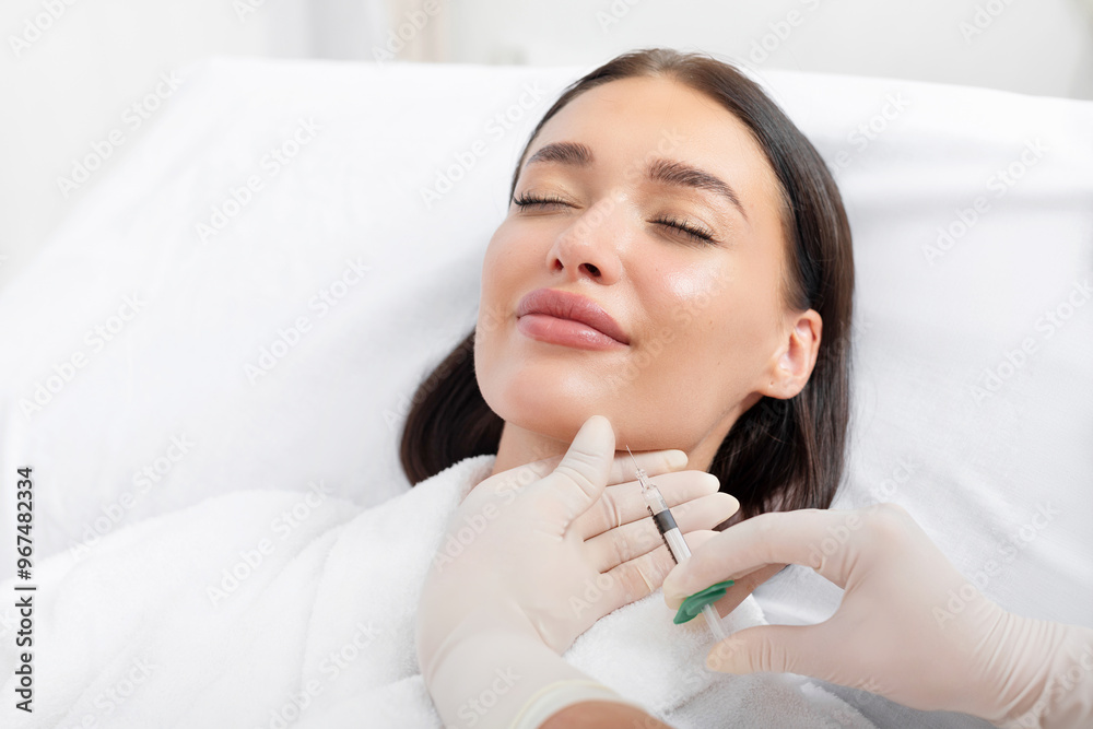 Professional cosmetologist making injections to correct chin form, lady ...