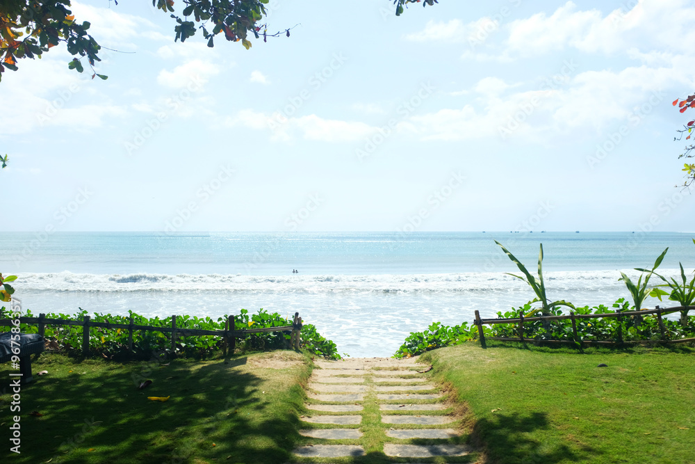 Sunny Beach Pathway Leading to the Ocean, Framed by Lush Greenery and a ...