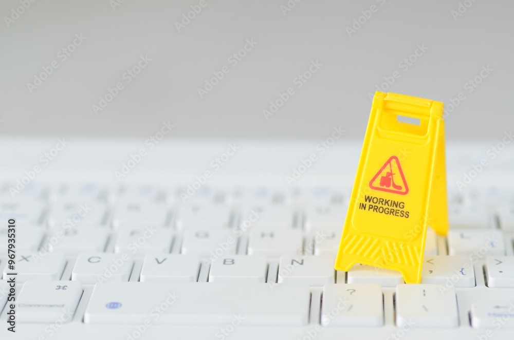 The caution sign, positioned on a keyboard, serves as a visual metaphor ...