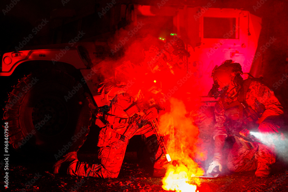 soldiers wearing combat gear gather around a flare during military ...