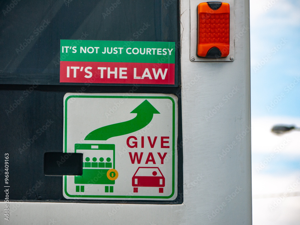 Sign with the text 'IT'S NOT JUST COURTESY, IT'S THE LAW,' showing a ...