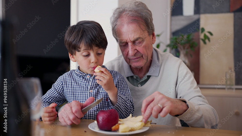 Grandfather and grandson enjoying apple slices, family time ...